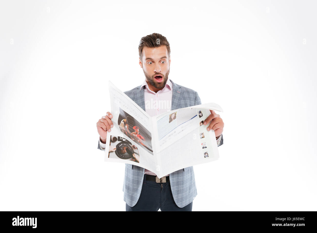 Photo of shocked young man standing isolated over white background and ...