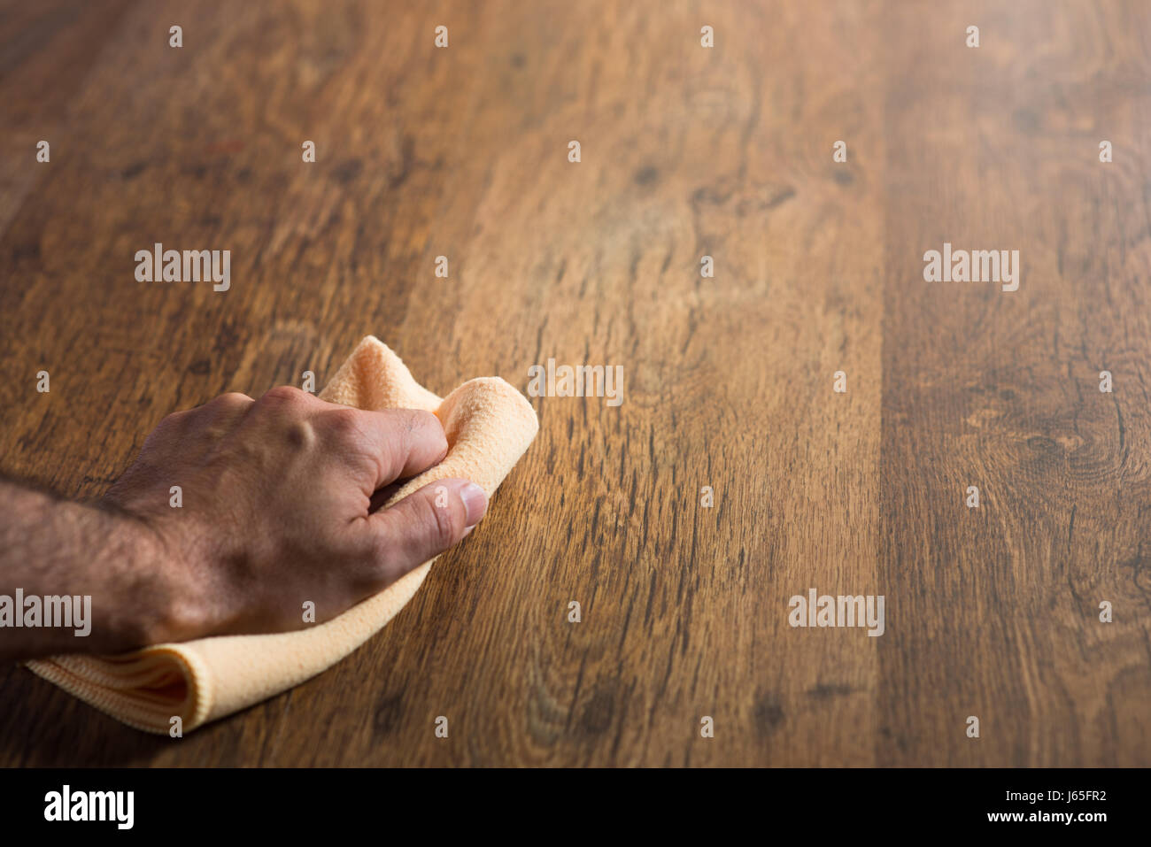 Male hand cleaning and rubbing an hardwood floor with a microfiber ...