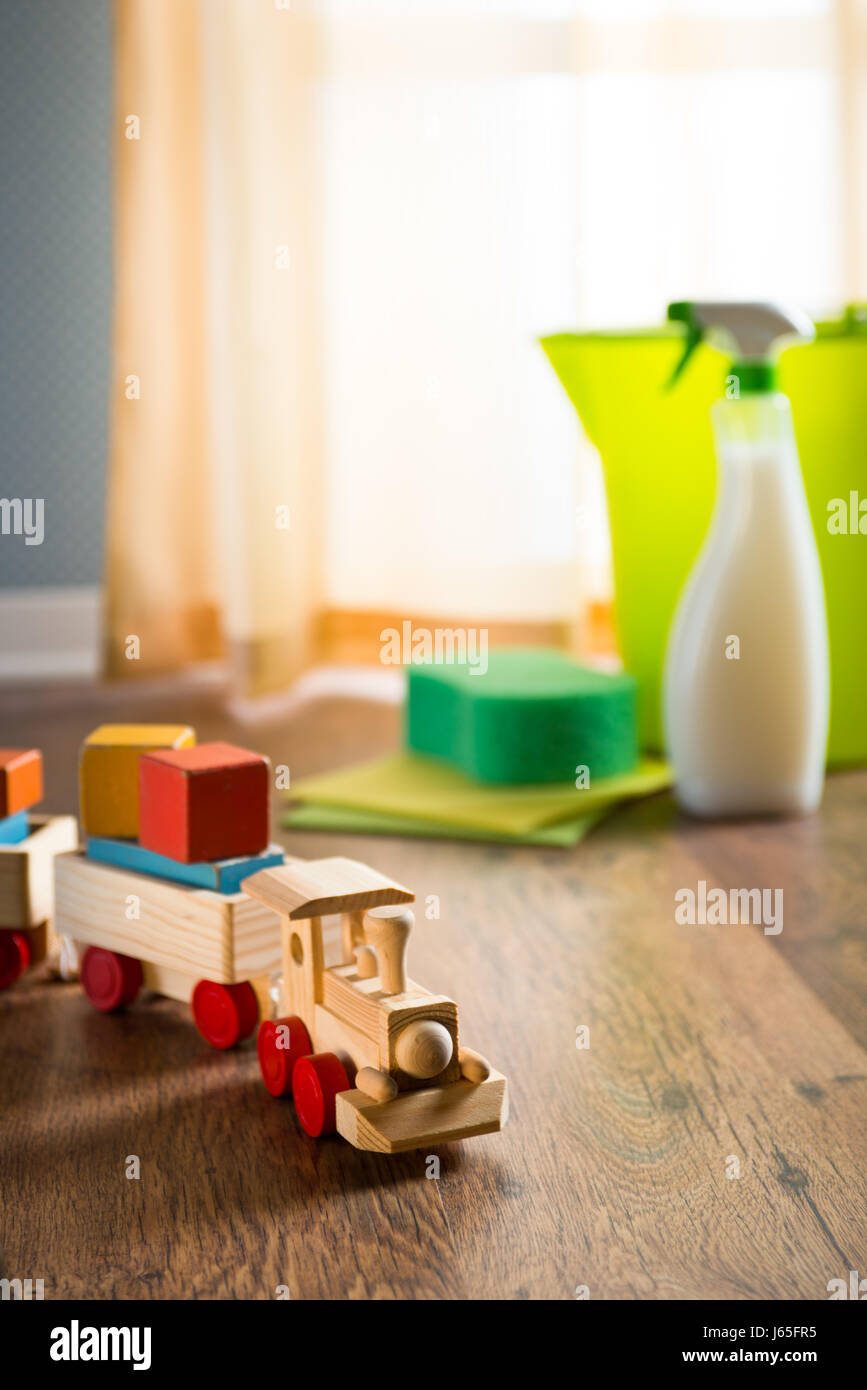 Wooden toy train with cleaning products on background next to a window ...