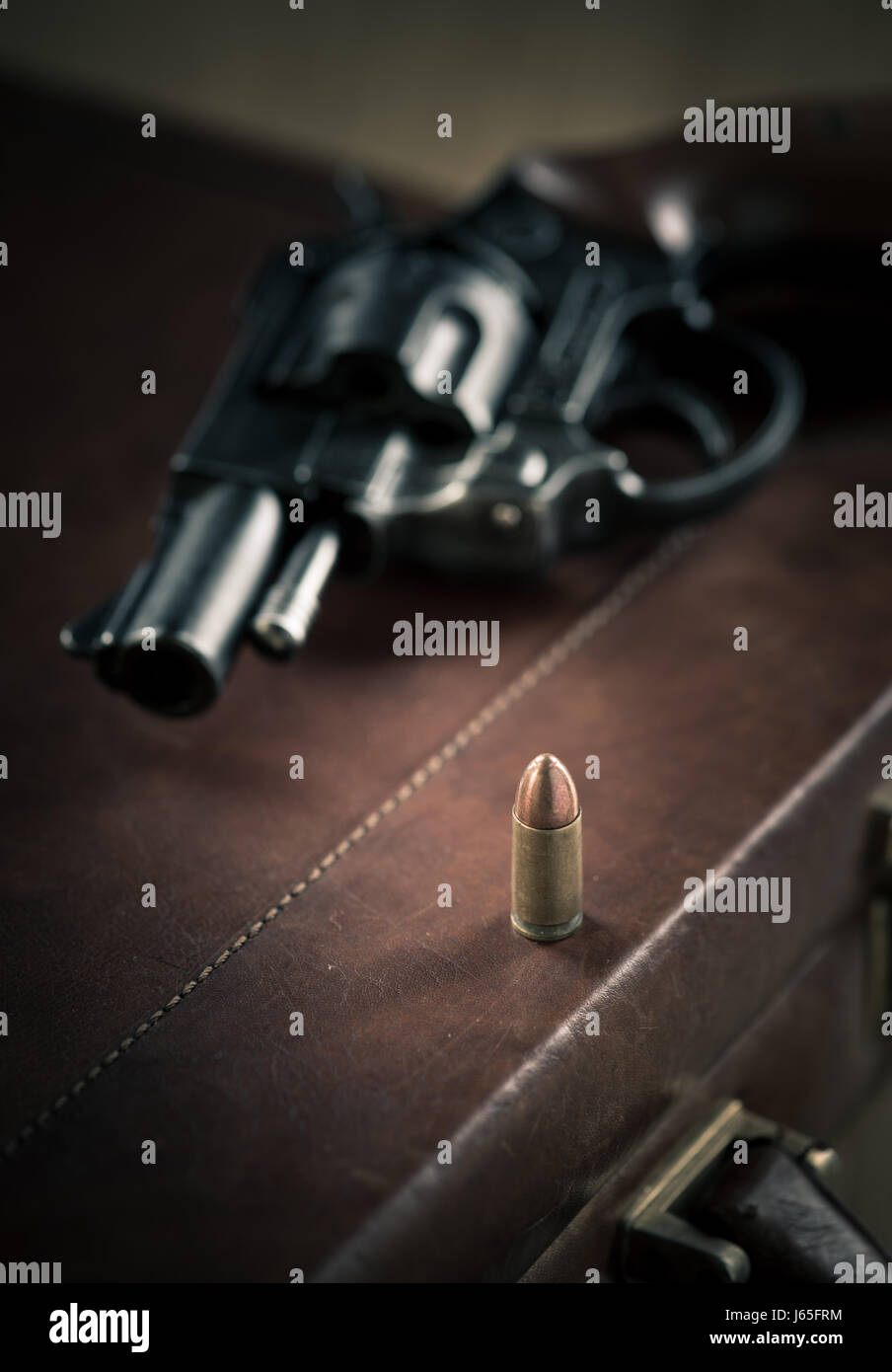 Vintage revolver gun on leather briefcase with bullet close-up Stock ...