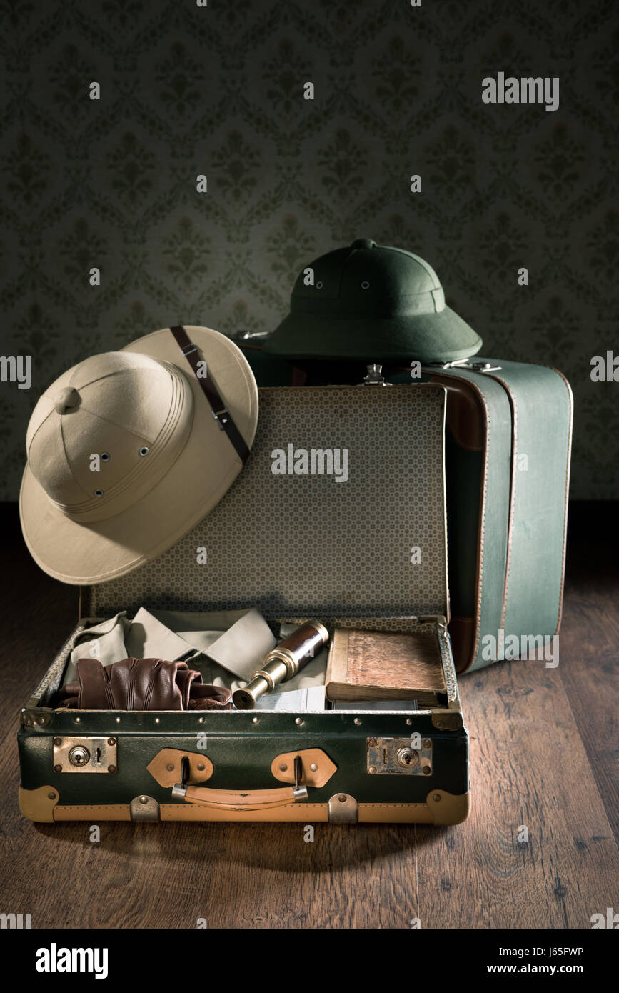 Open suitcase with colonial style explorer equipment including pith ...