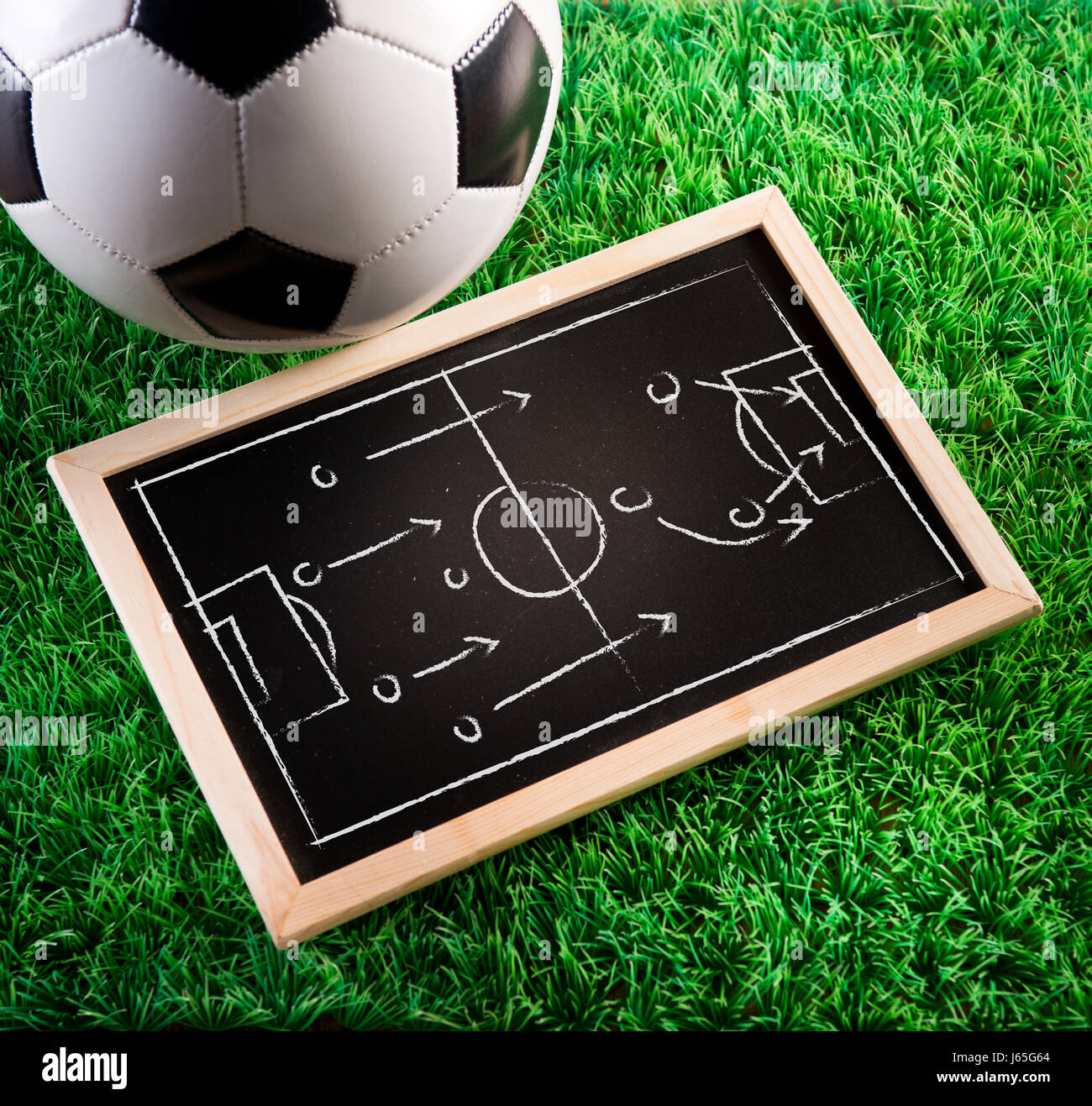 Blackboard with game tactics with soccer ball and green turf on ...