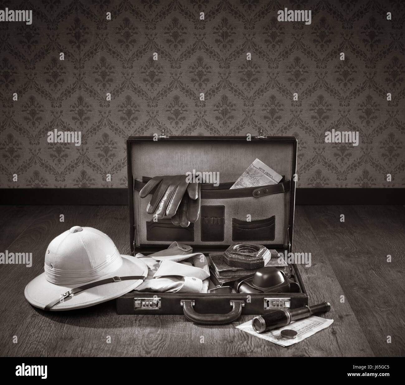 Colonial style explorer packing with open leather briefcase, pith hat ...