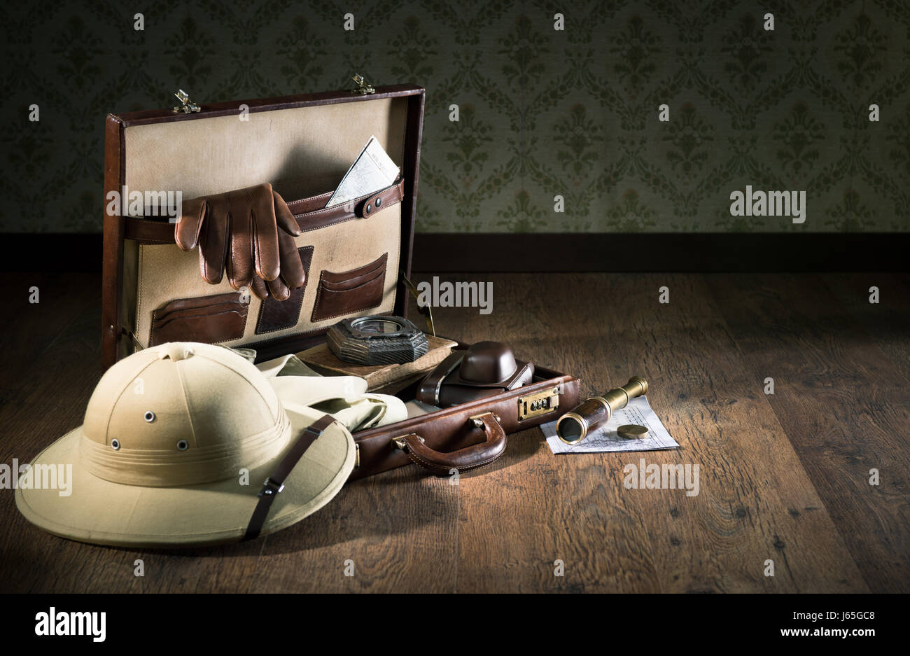Colonial style explorer packing with open leather briefcase, pith hat ...