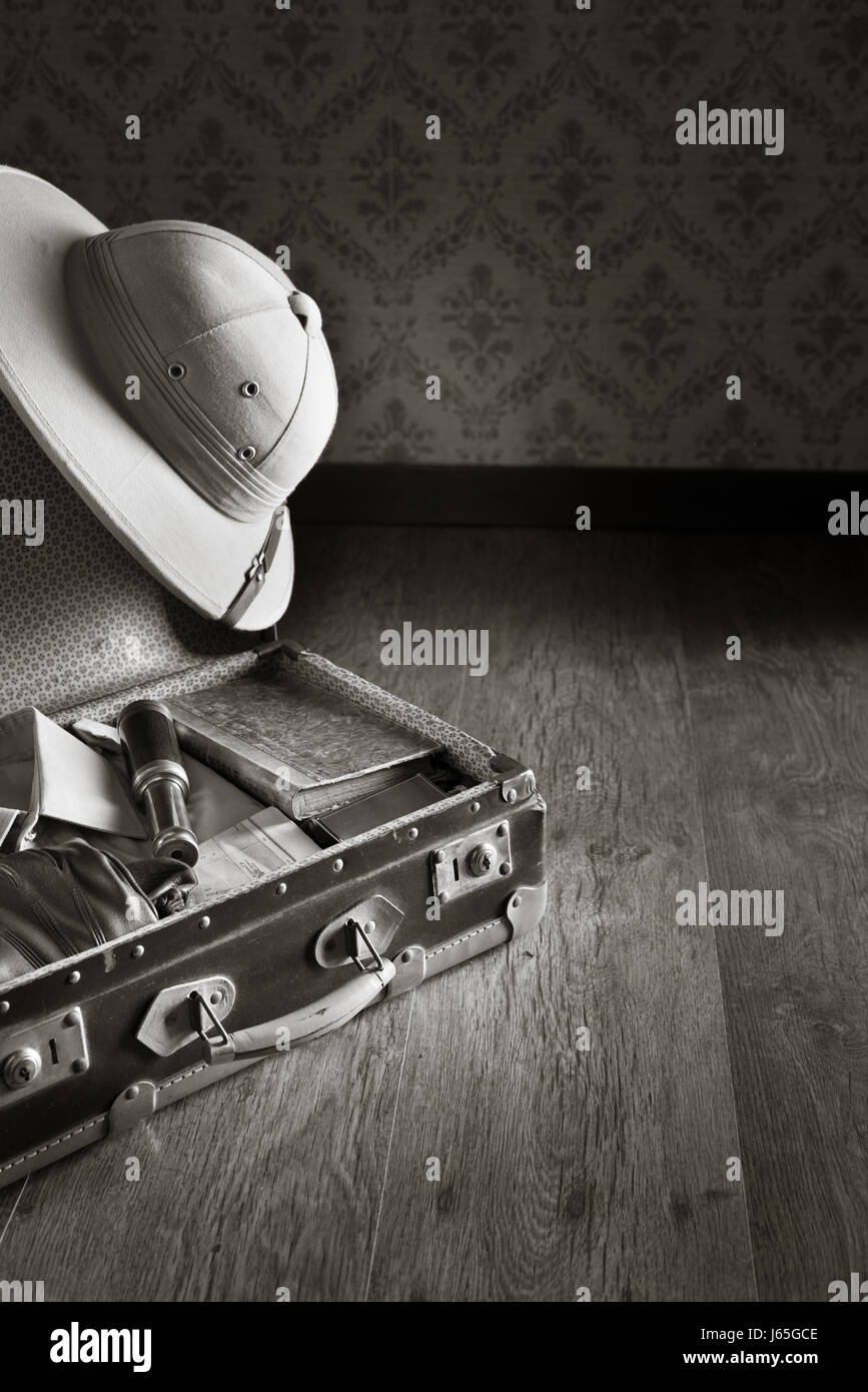 Open suitcase with colonial style explorer equipment including pith ...