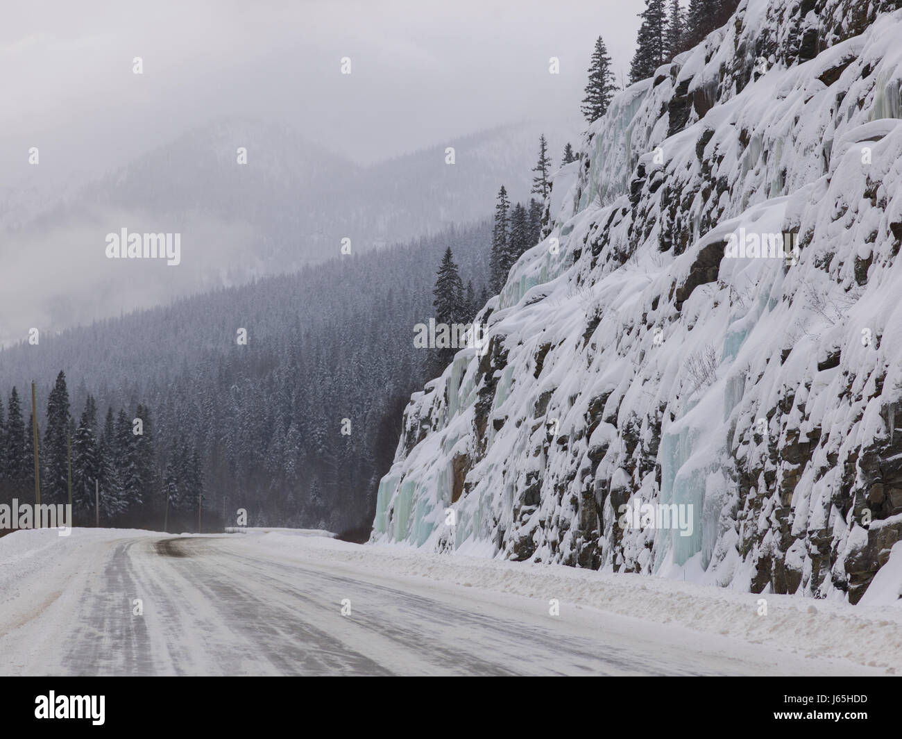 Snow covered road passing through forest, British Columbia Highway 97 ...