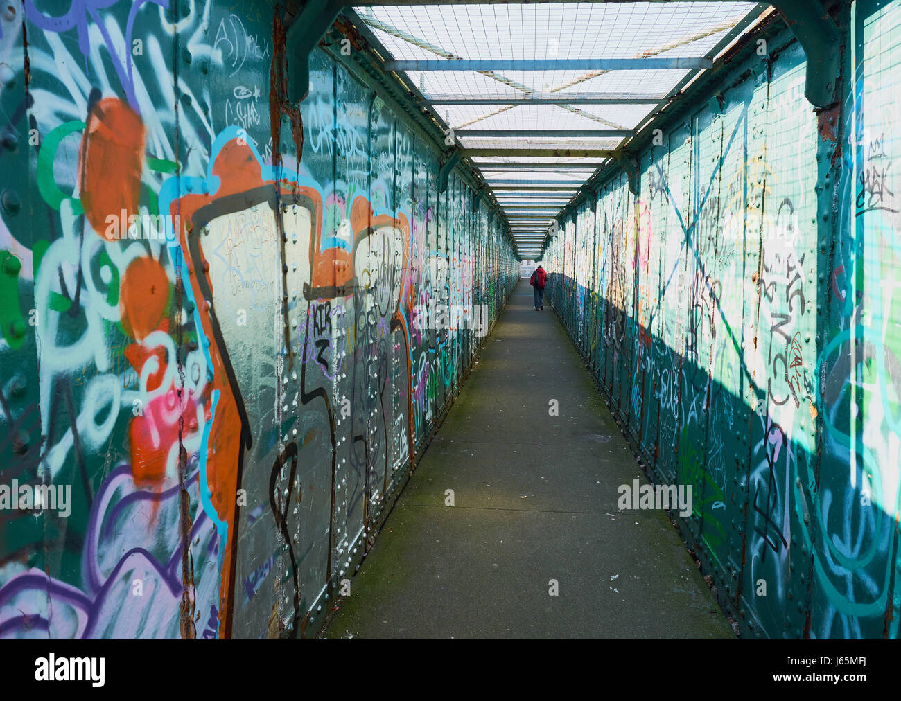 Man walking along graffiti covered pedestrian walkway, Sheffield, South ...