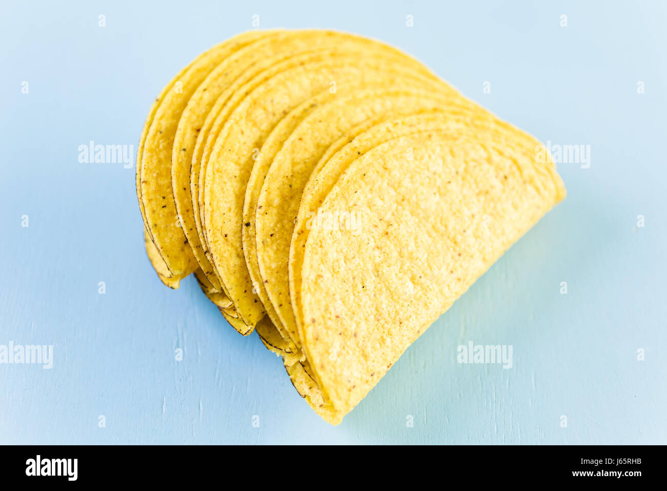 Yellow corn taco shells on a blue background Stock Photo - Alamy