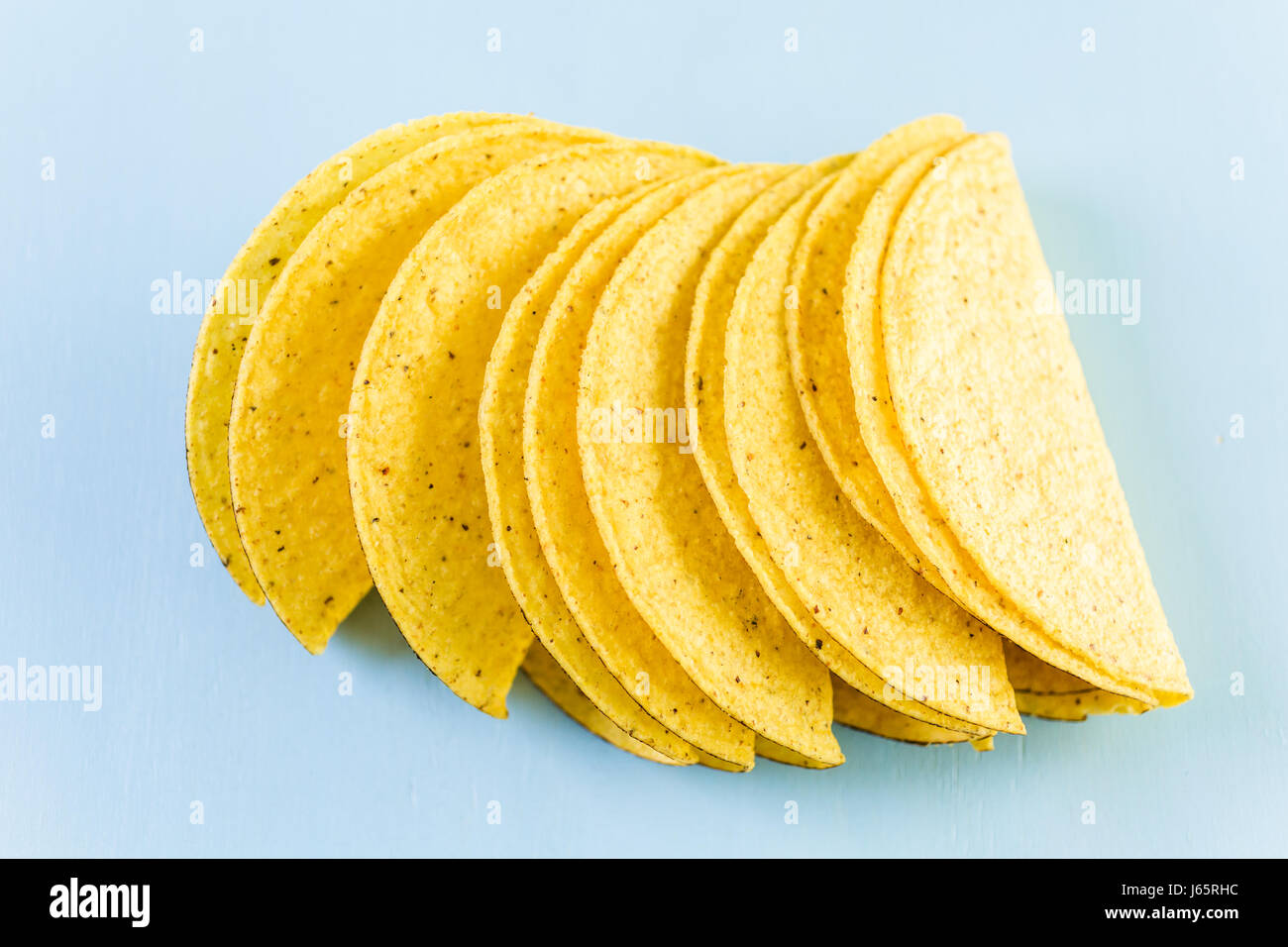 Yellow corn taco shells on a blue background Stock Photo - Alamy