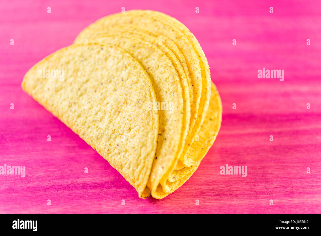 Yellow corn taco shells on a pink background Stock Photo - Alamy