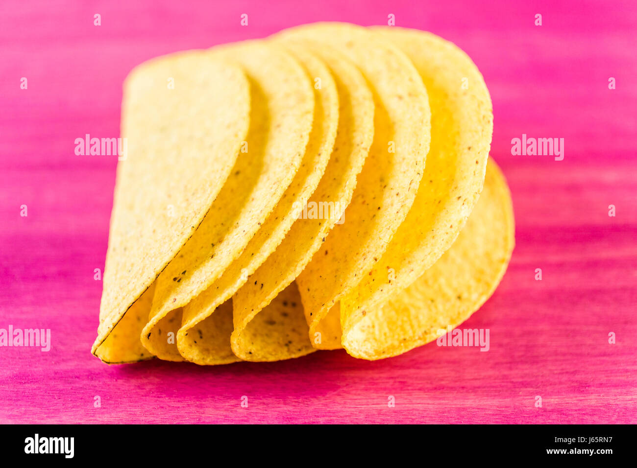 Yellow corn taco shells on a pink background Stock Photo - Alamy