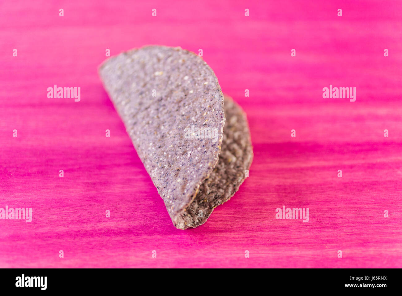 Blue corn taco shells on a pink background Stock Photo - Alamy