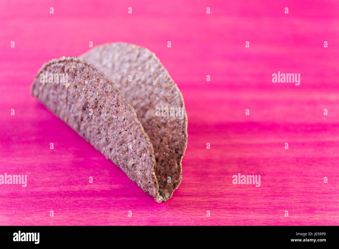 Blue corn taco shells on a pink background Stock Photo - Alamy