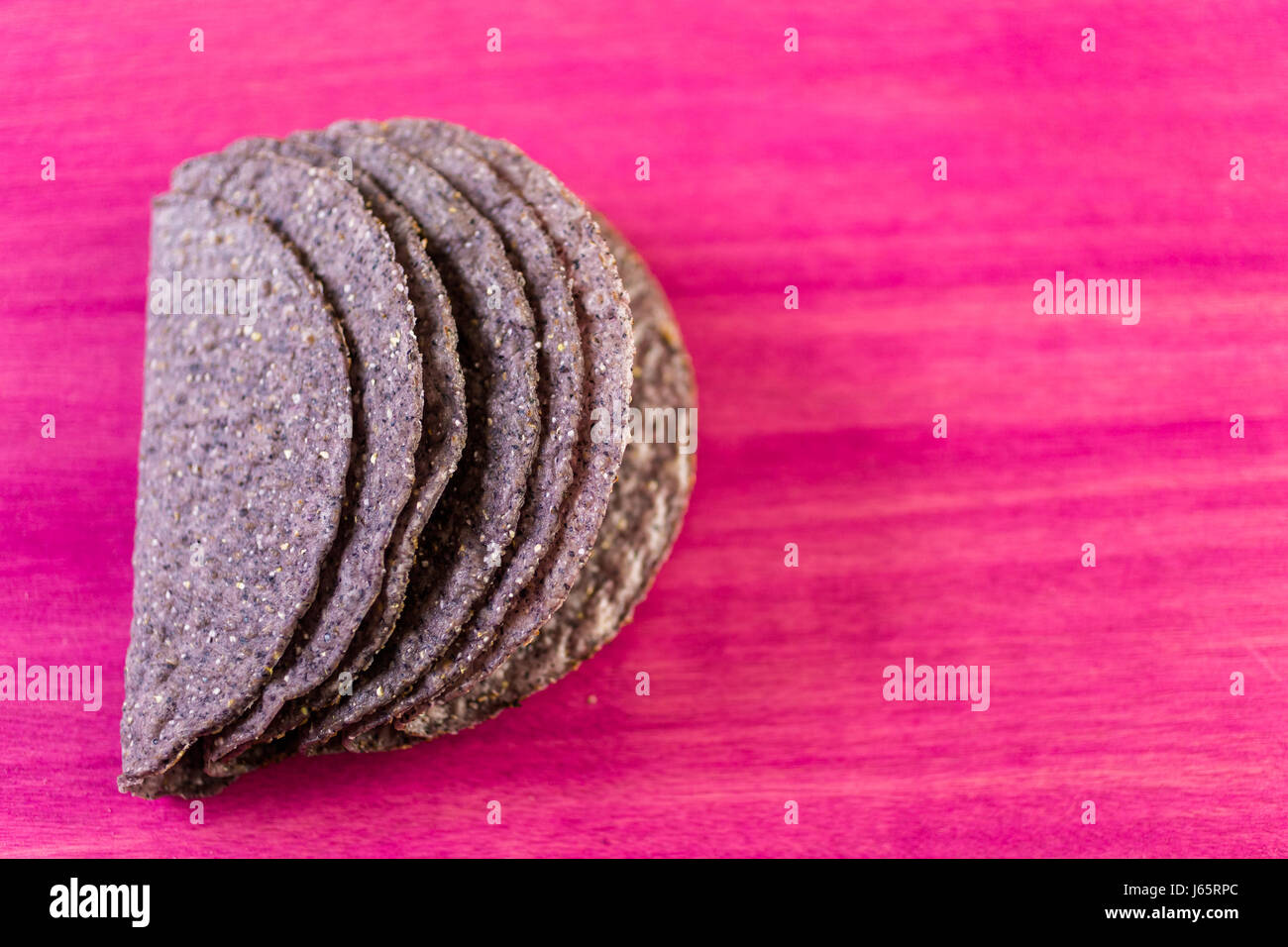 Blue corn taco shells on a pink background Stock Photo - Alamy
