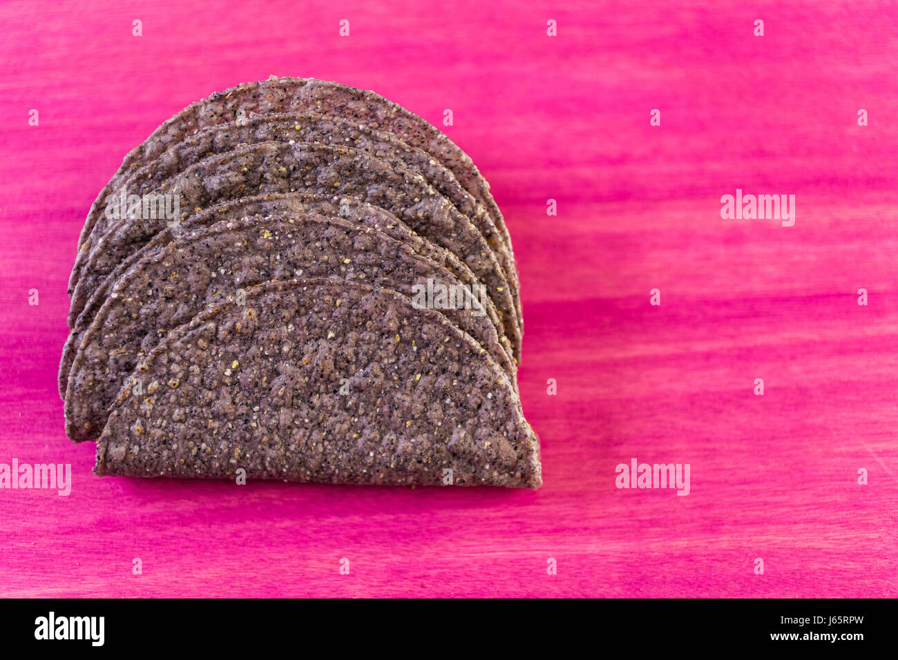 Blue corn taco shells on a pink background Stock Photo - Alamy