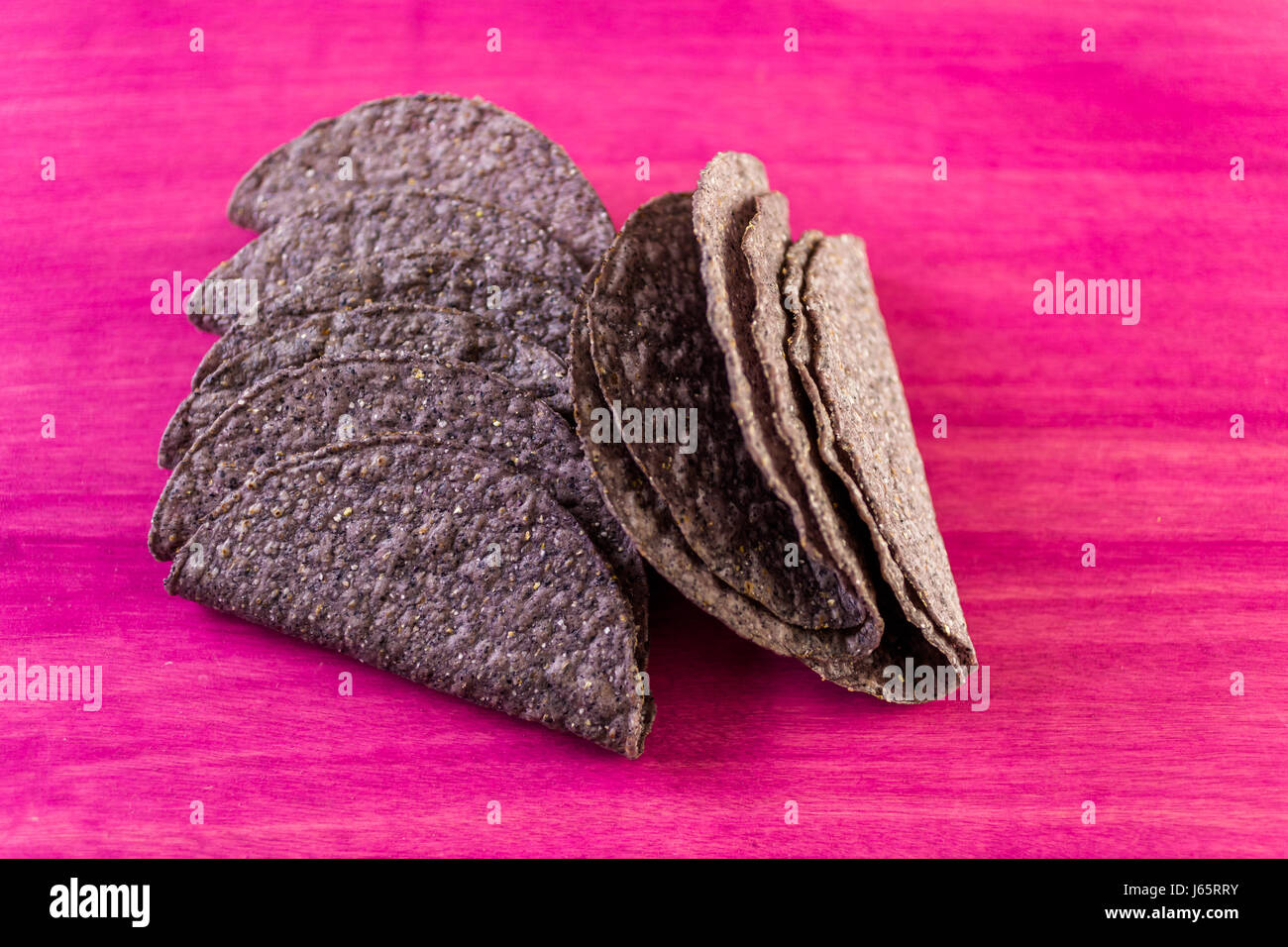 Blue corn taco shells on a pink background Stock Photo - Alamy
