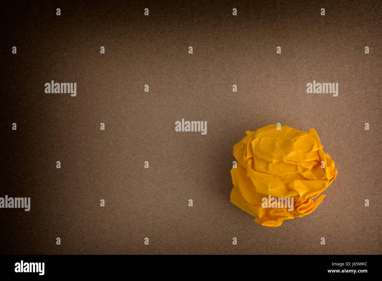 Yellow crumpled paper ball on a brown background. Idea Concept Stock ...
