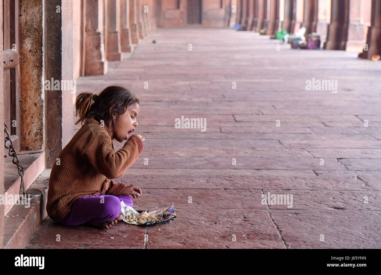 A poor girl eating in Fatehpur Sikri complex, Uttar Pradesh, India on ...
