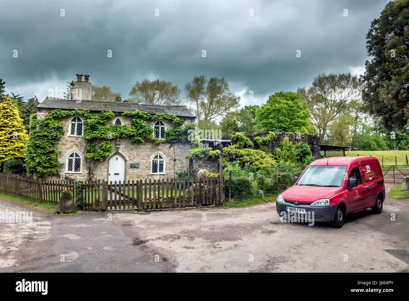Postman delivering letters to some classic English village properties ...
