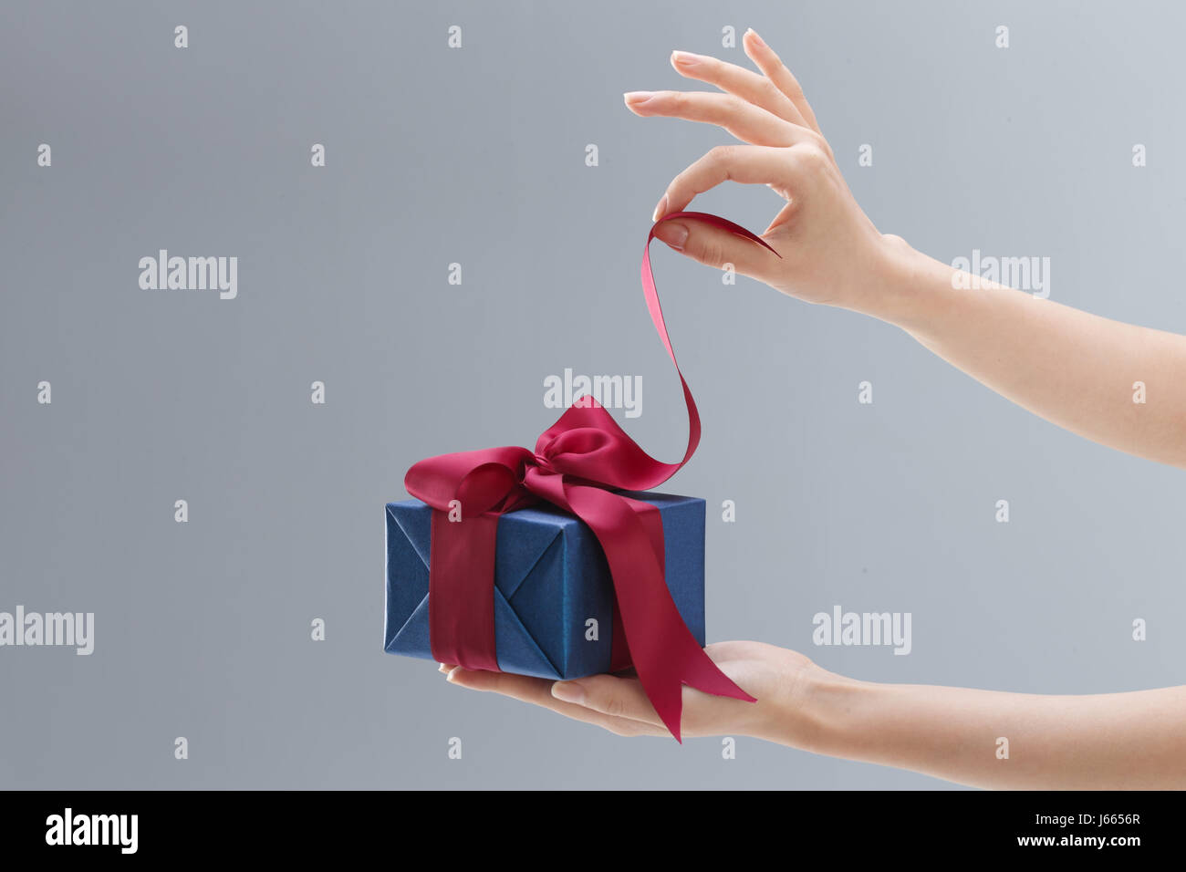 Hand holding a gift box Stock Photo - Alamy
