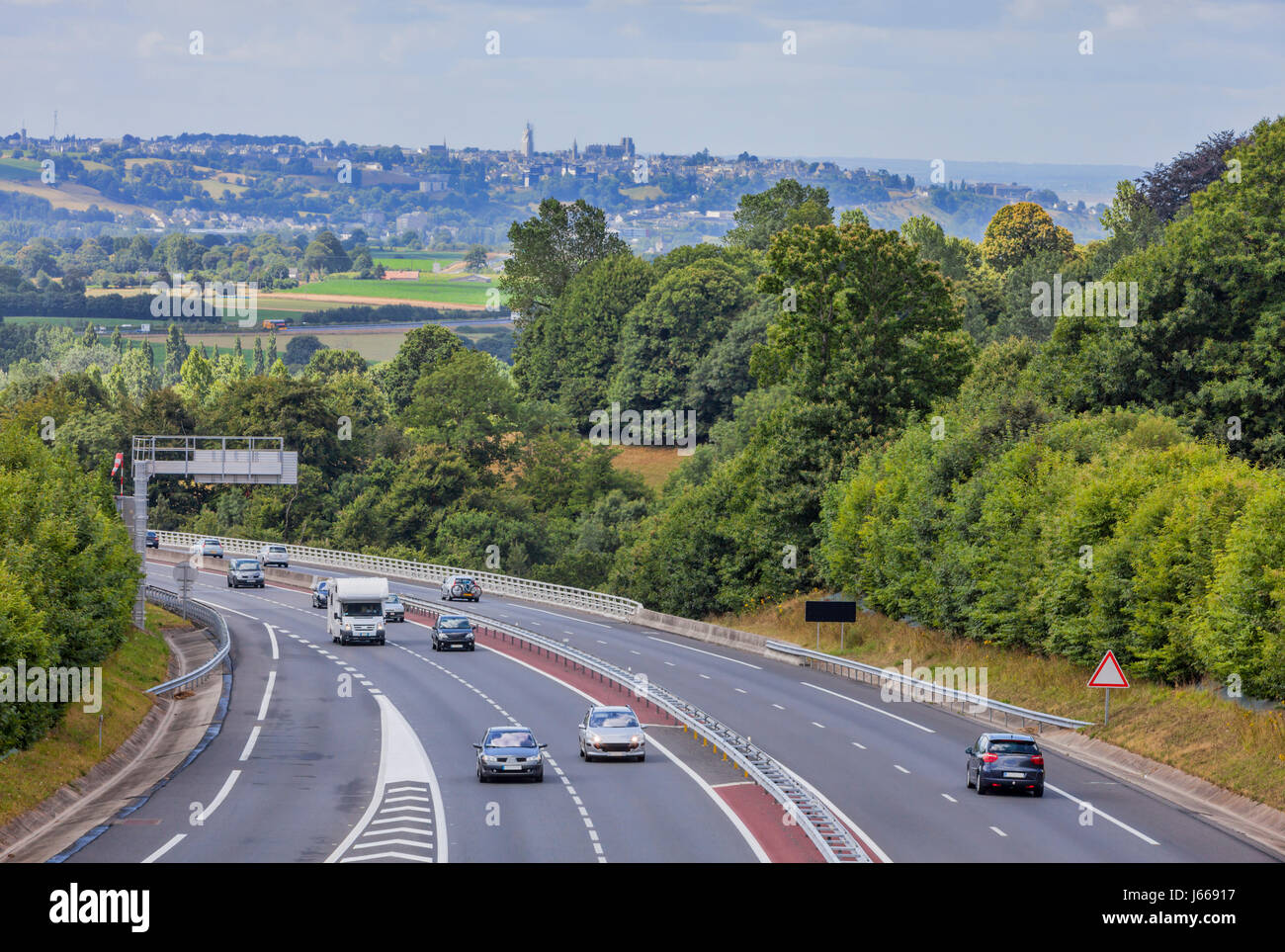 Moderate traffic on a highway between the forests in Normandy,France ...