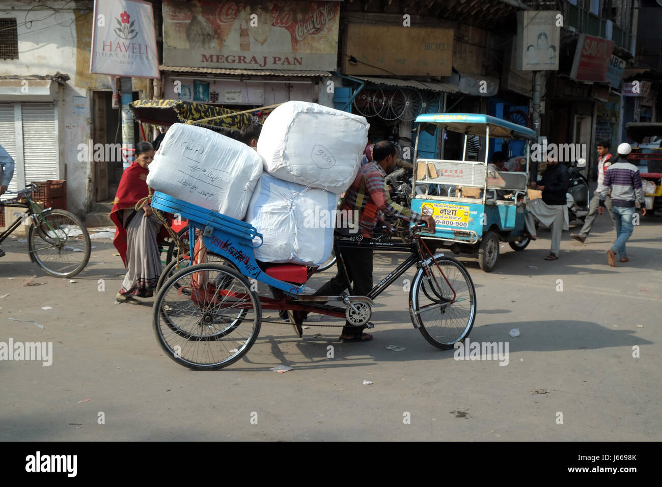 Hard working Indians pushing heavy load through streets of Delhi, India ...
