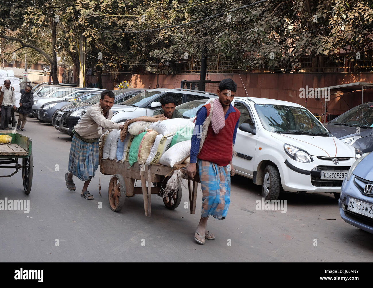 Hard working indians pushing heavy load through streets of Delhi, India ...