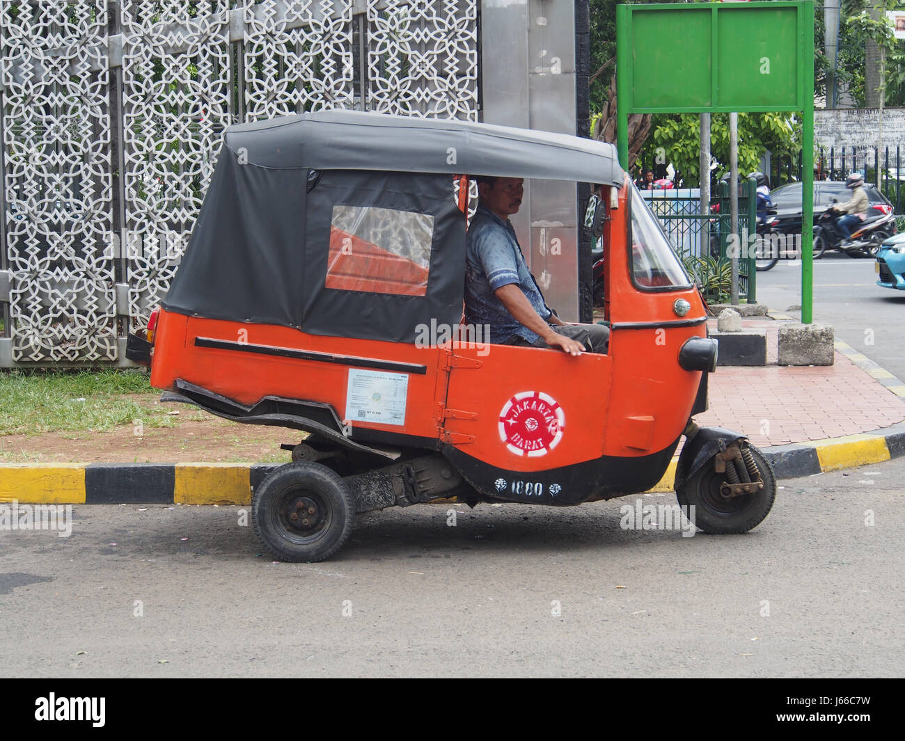 Jakarta, Indonesia - January 11, 2015: Orange, three-wheeled car with a ...