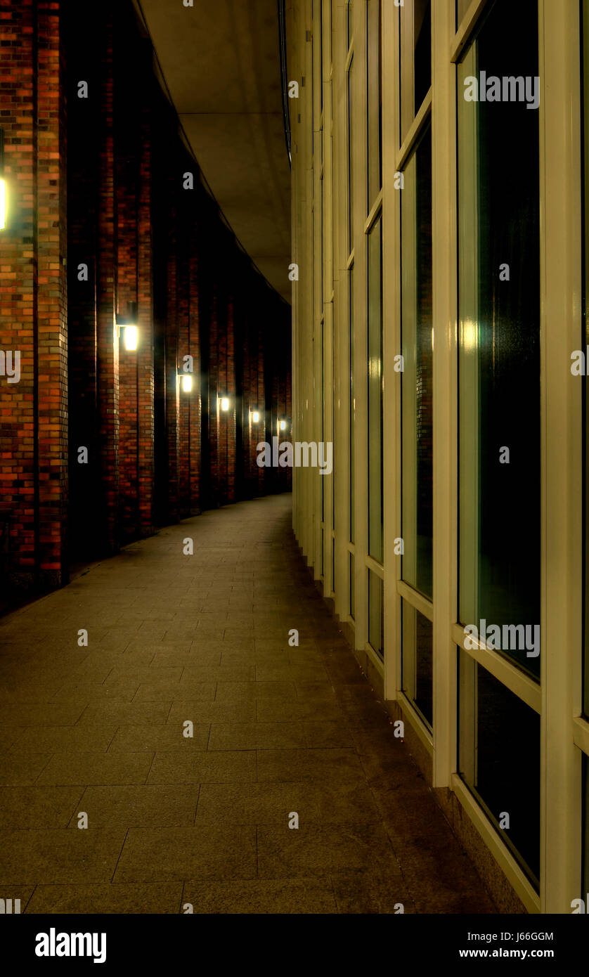 night photograph lighted pavement building buildings corridor window ...