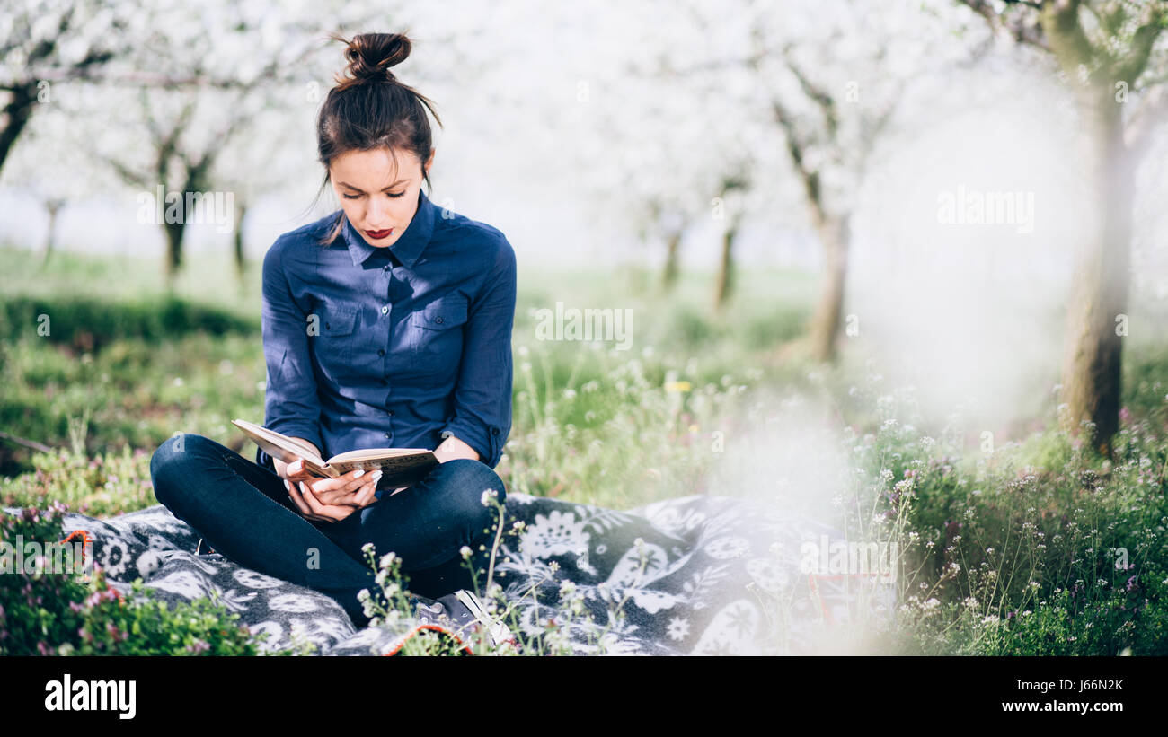 Girl reading a book in nature Stock Photo - Alamy