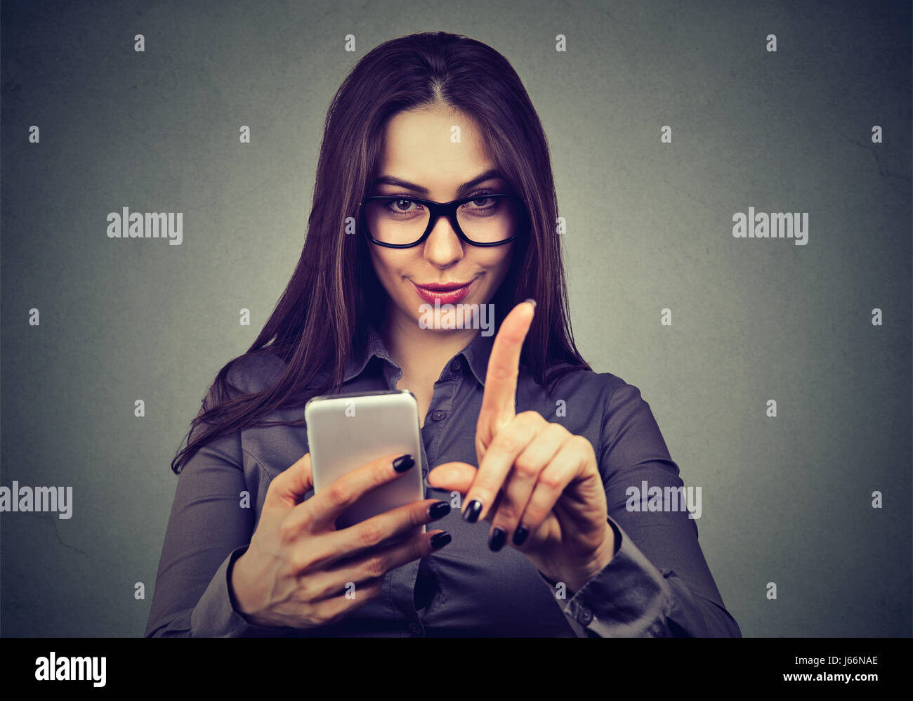 Young woman with smartphone showing no attention with finger hand ...