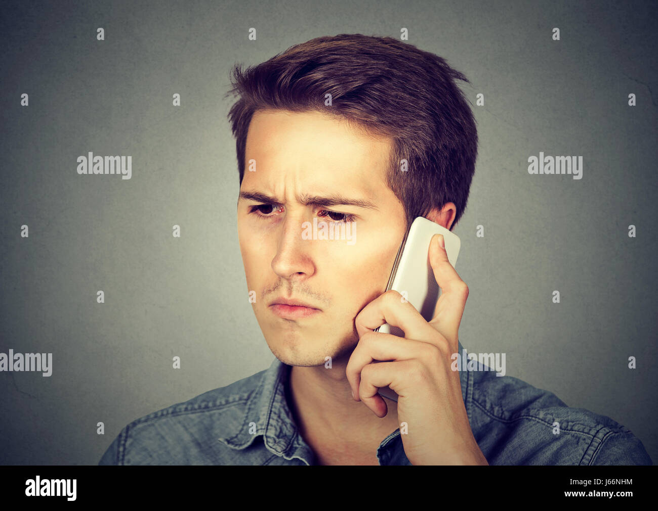 Serious sad man having mobile phone conversation Stock Photo - Alamy