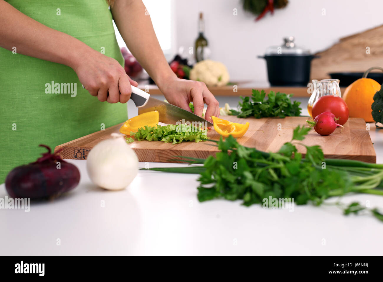 Close up of woman's hands cooking in the kitchen. Housewife slicing ...