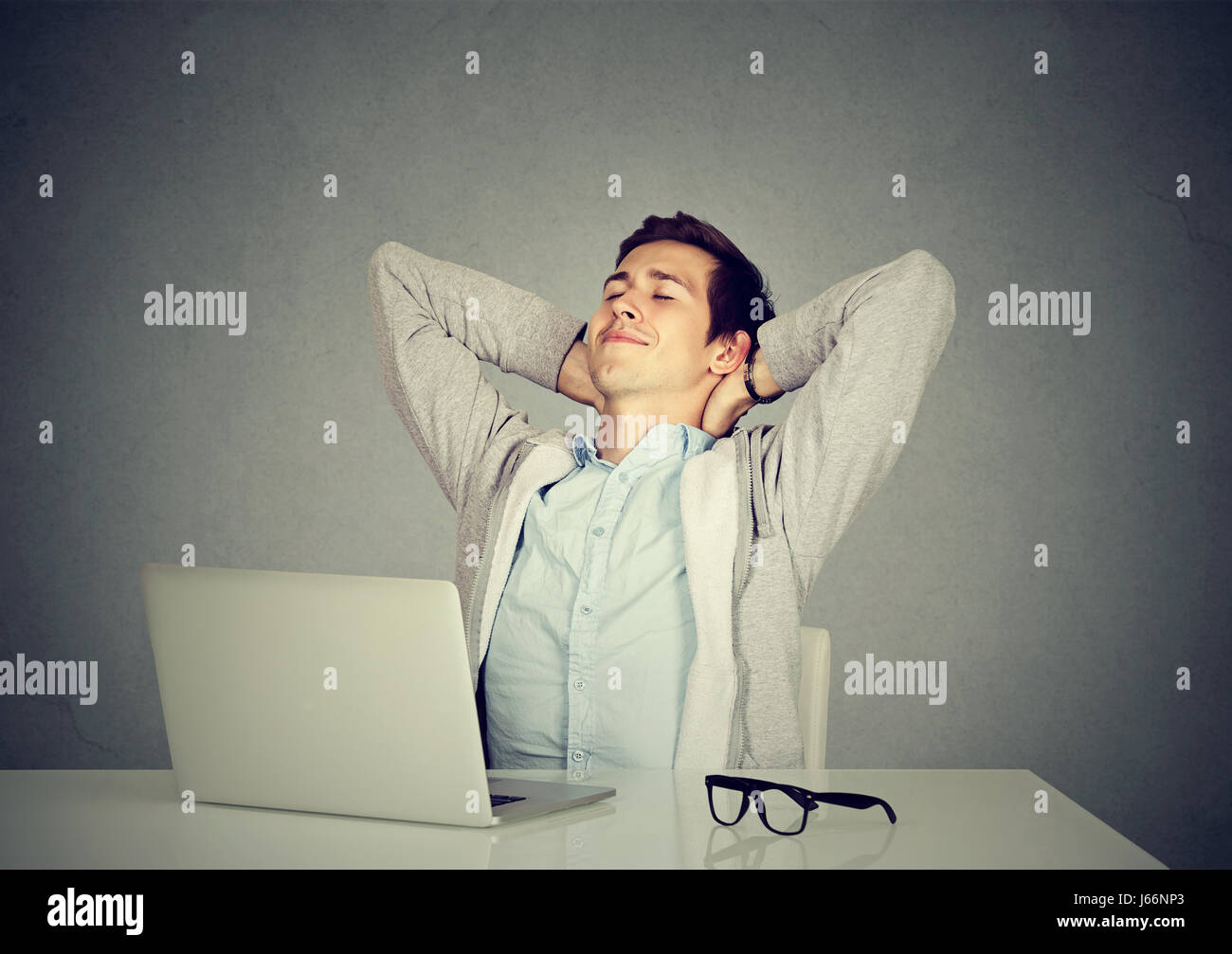 Young man relaxing at his desk Stock Photo - Alamy