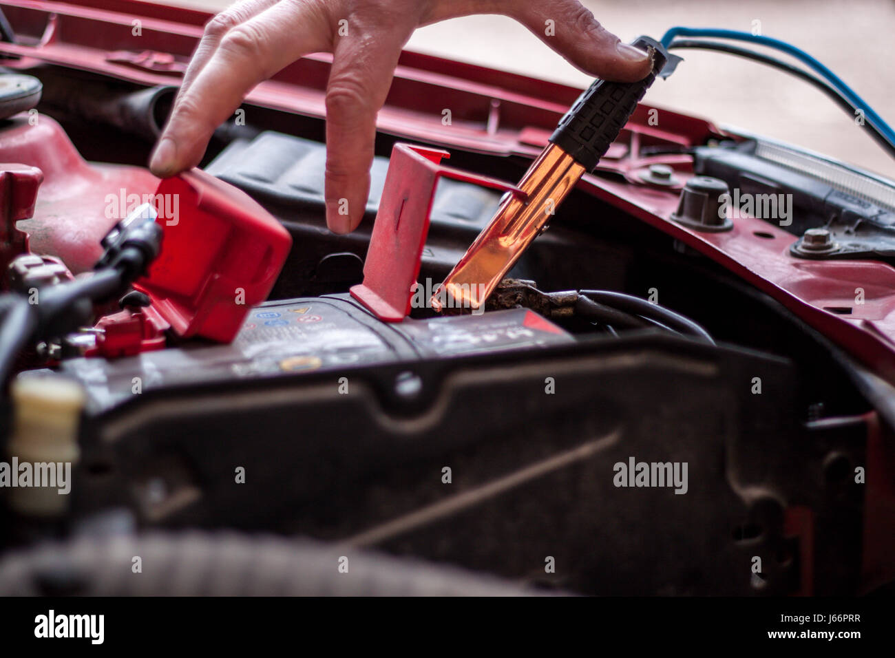 Car electrician manner by cables to the battery of the car Stock Photo ...