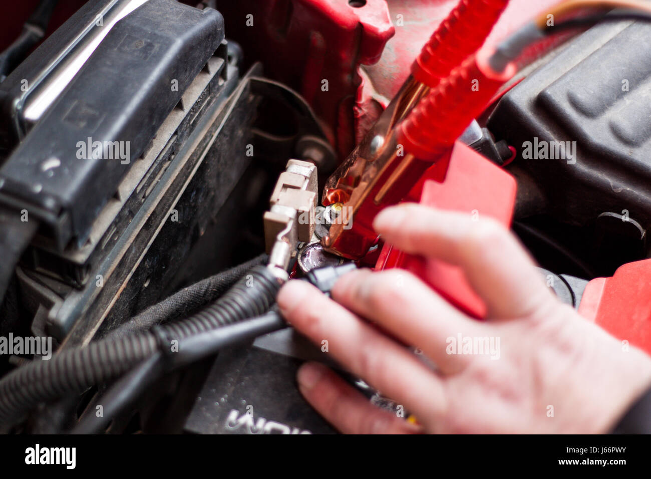 Car electrician manner by cables to the battery of the car Stock Photo ...