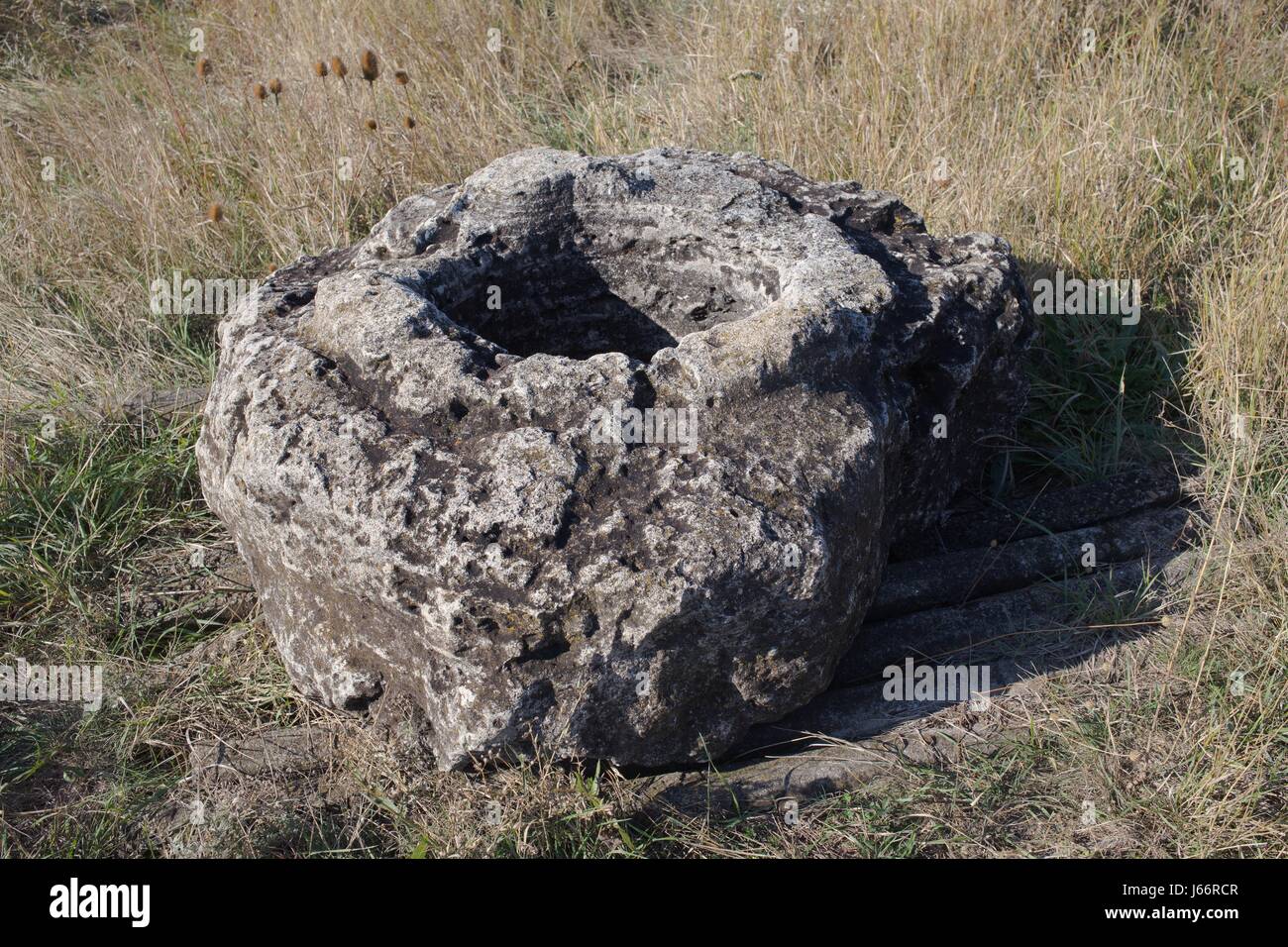 Stone old well. Close up of a stone old well located on a dry earth ...