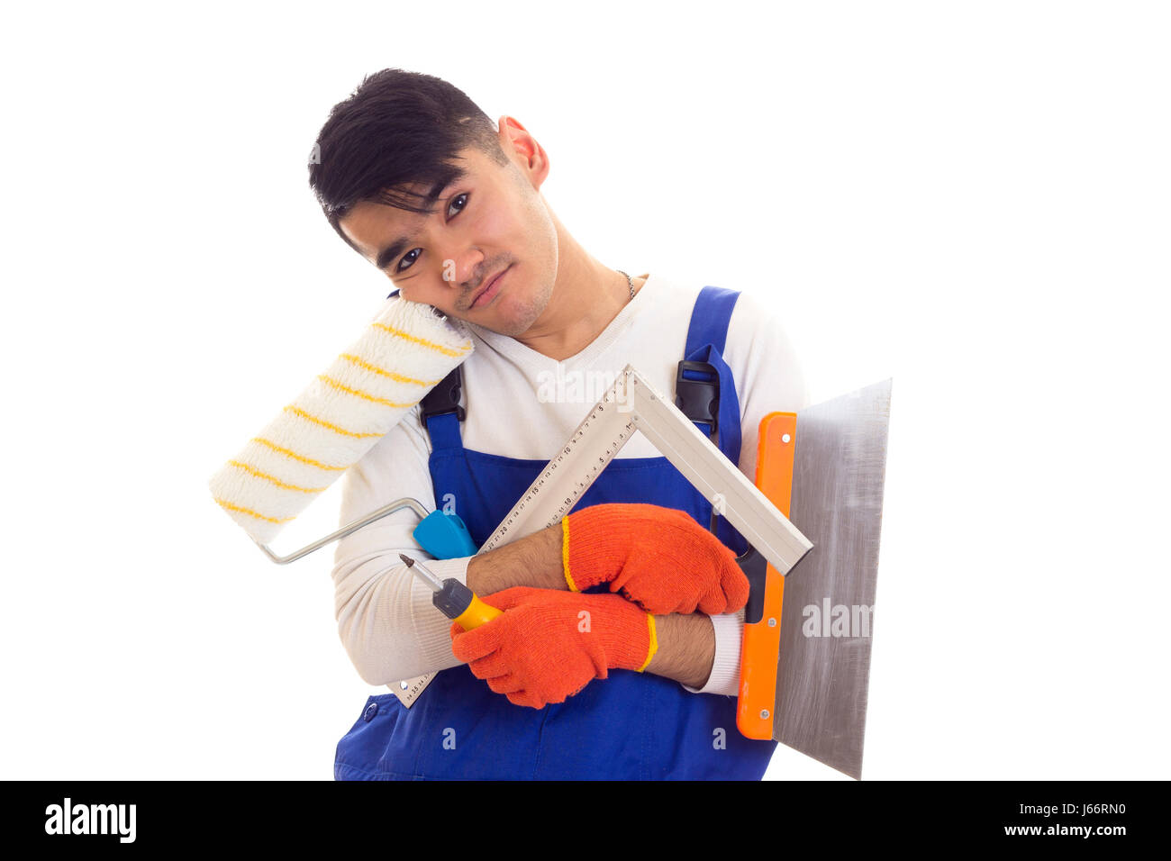 Man in overall with gloves holding spatula, roll, ruler and screwdriver ...