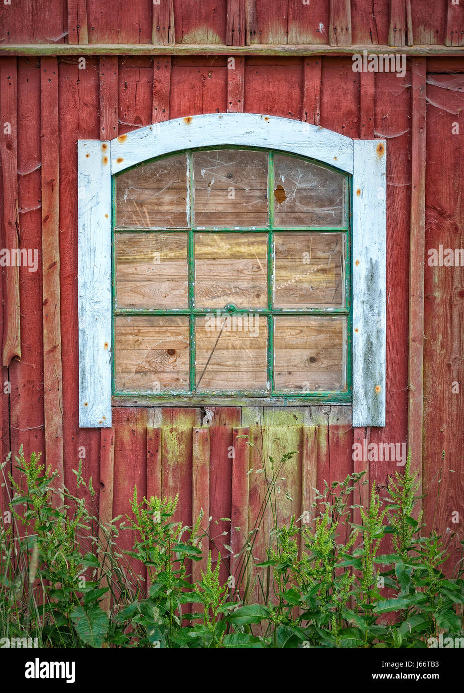 A boarded up broken window of a classic red countryside barn Stock ...