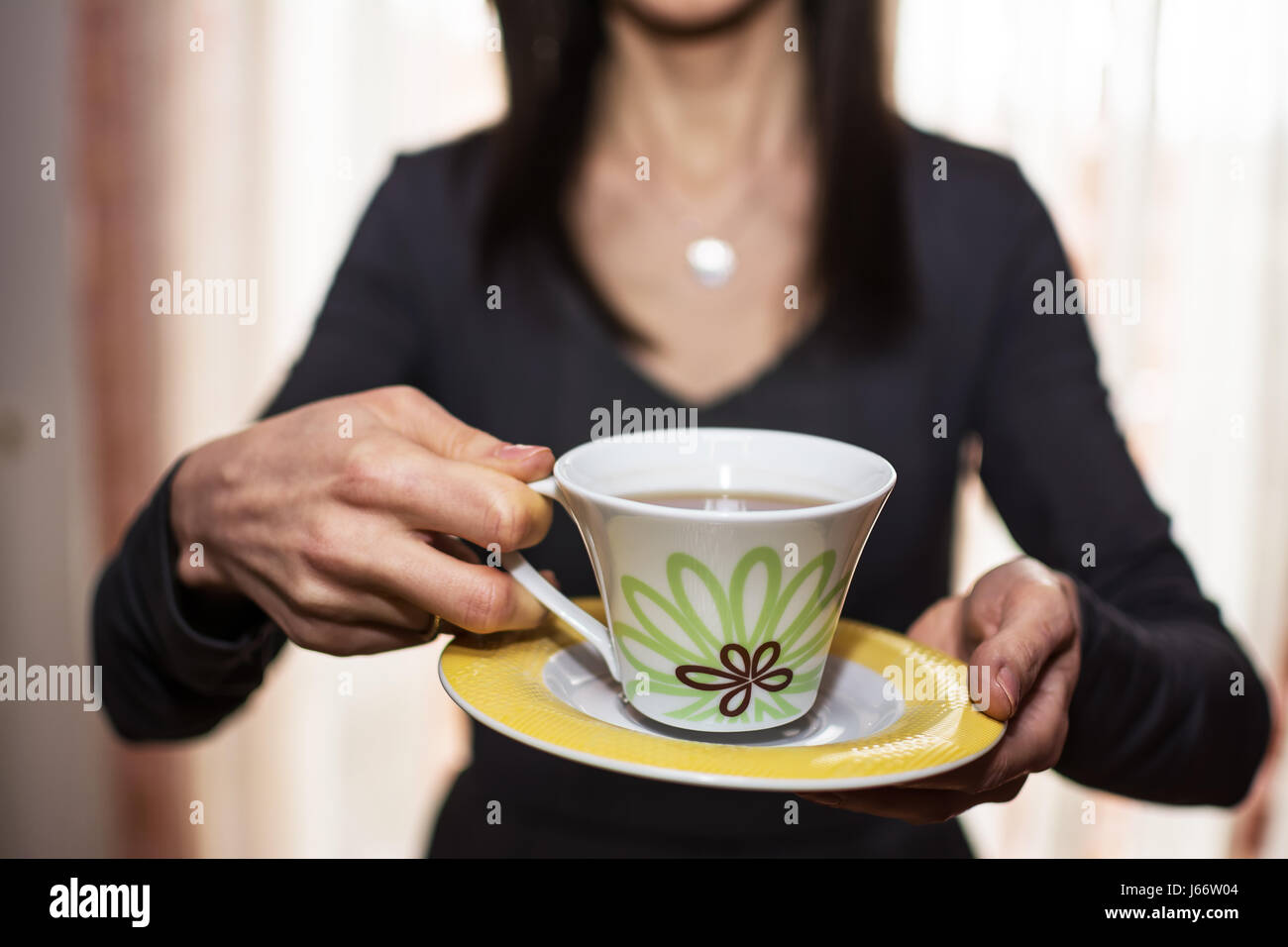 Woman offering a cup of tea (blurring Stock Photo - Alamy