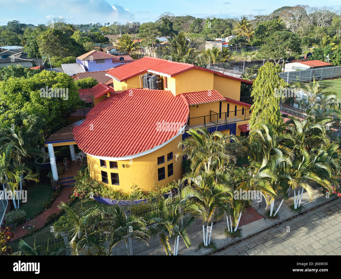 Big yellow house with balcony aerial view. House in tropical country ...