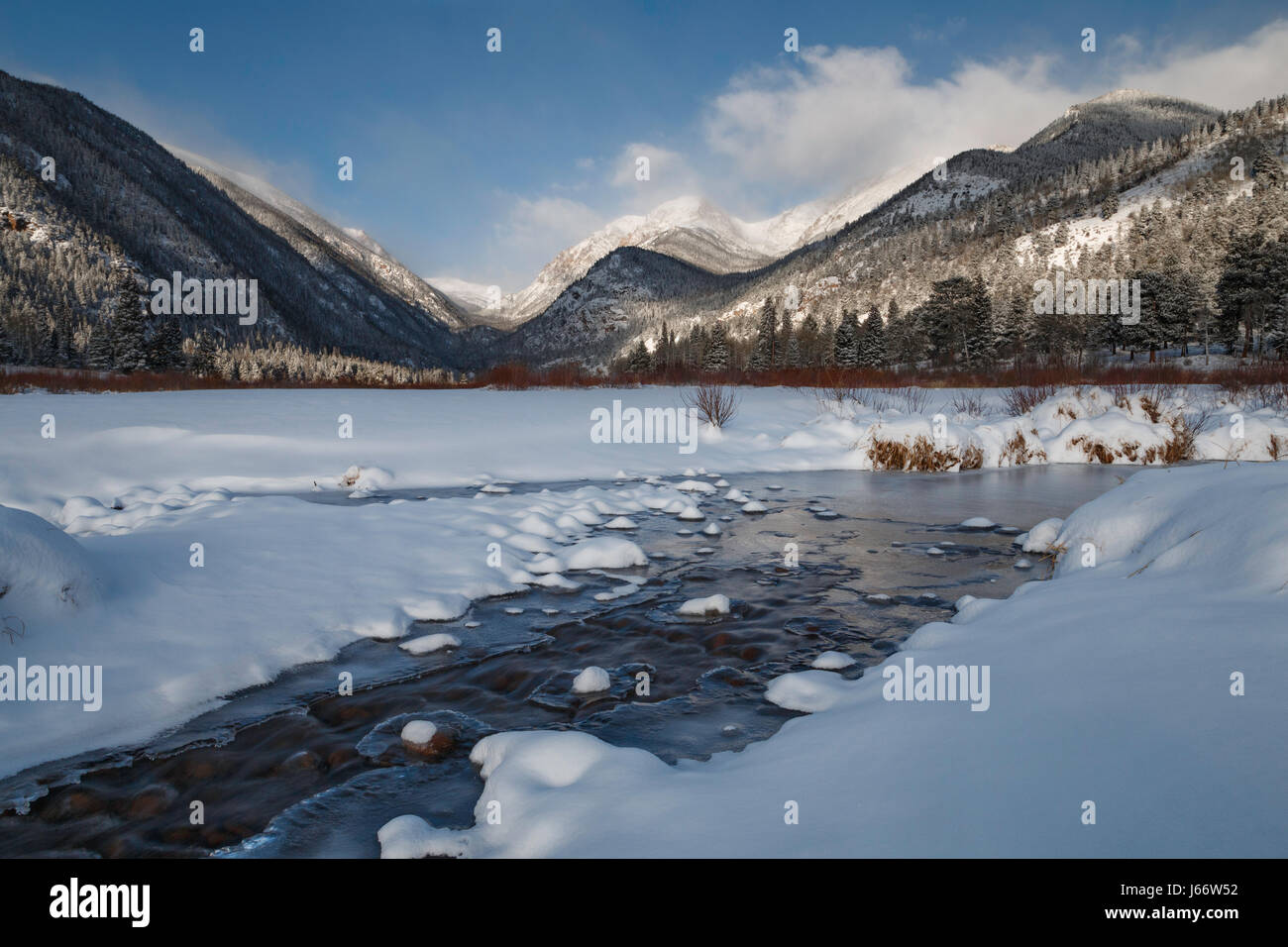 Water flows through a partially frozen Fall River with morning sunlight ...