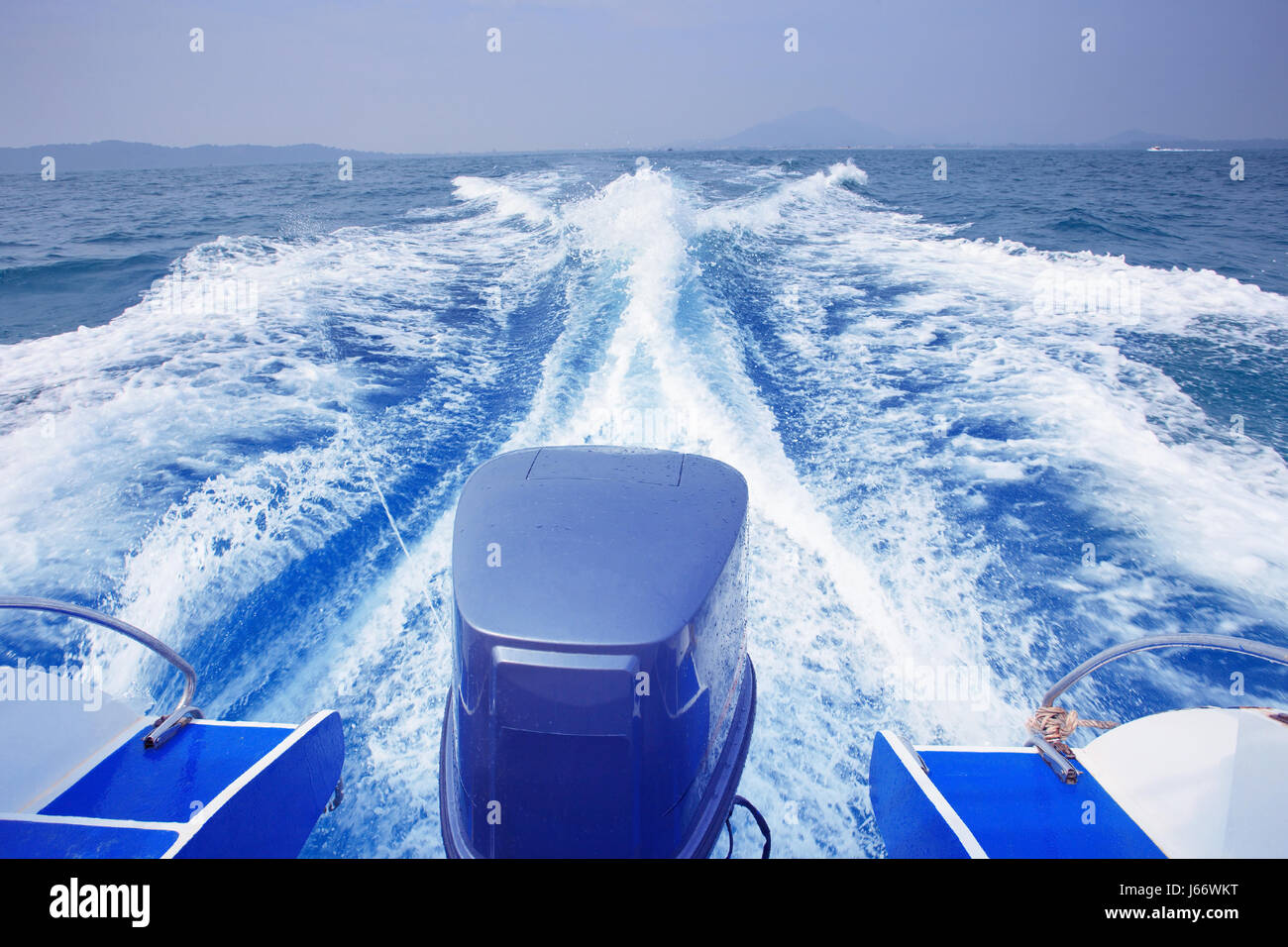 rear view of speed boat running high speed on blue sea water use for ...