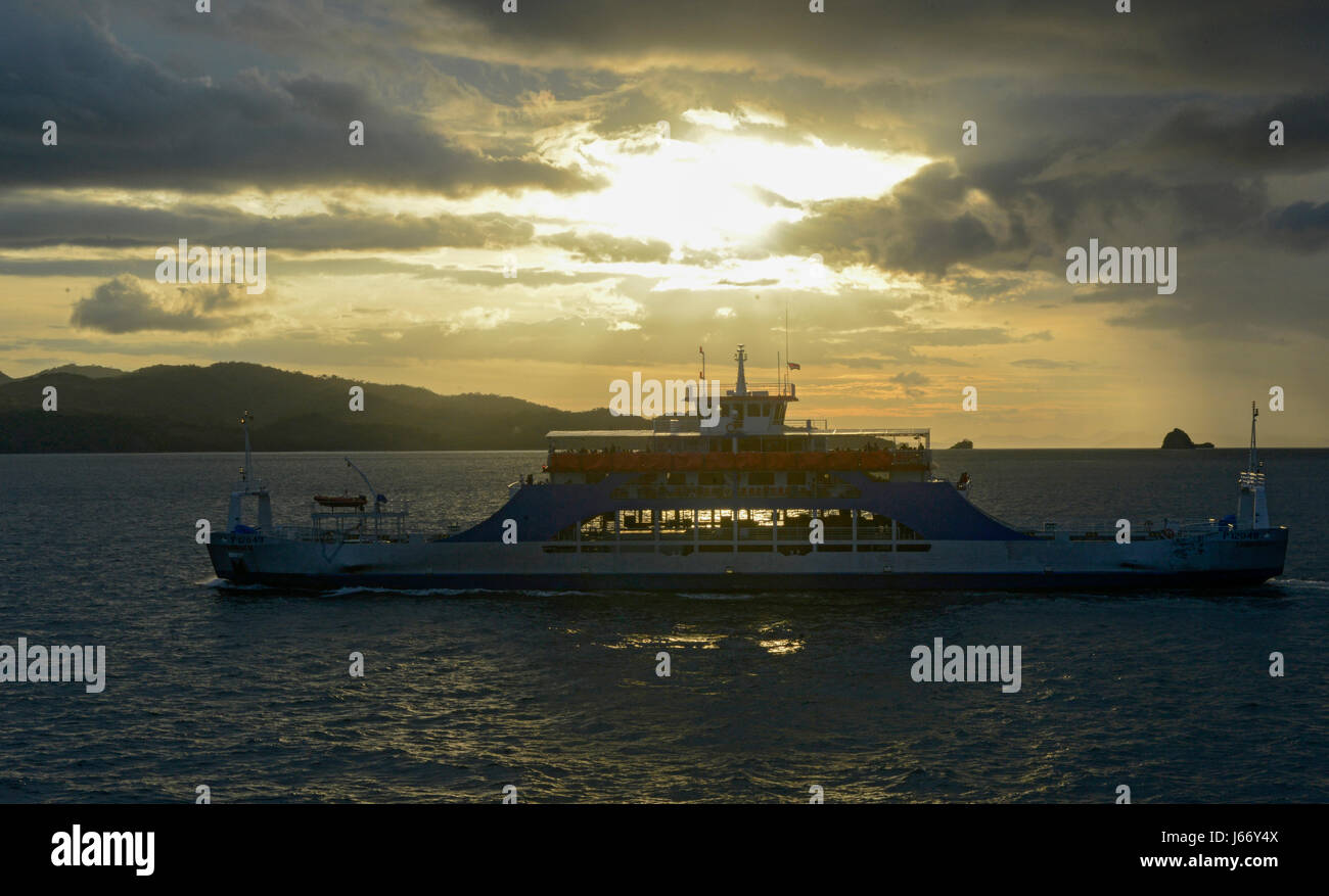 The tambor ferry passes under a sunset near the Nicoya Peninsula in ...
