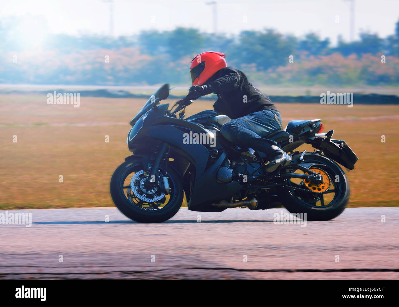 young man riding motorcycle in asphalt road curve with with a moving ...