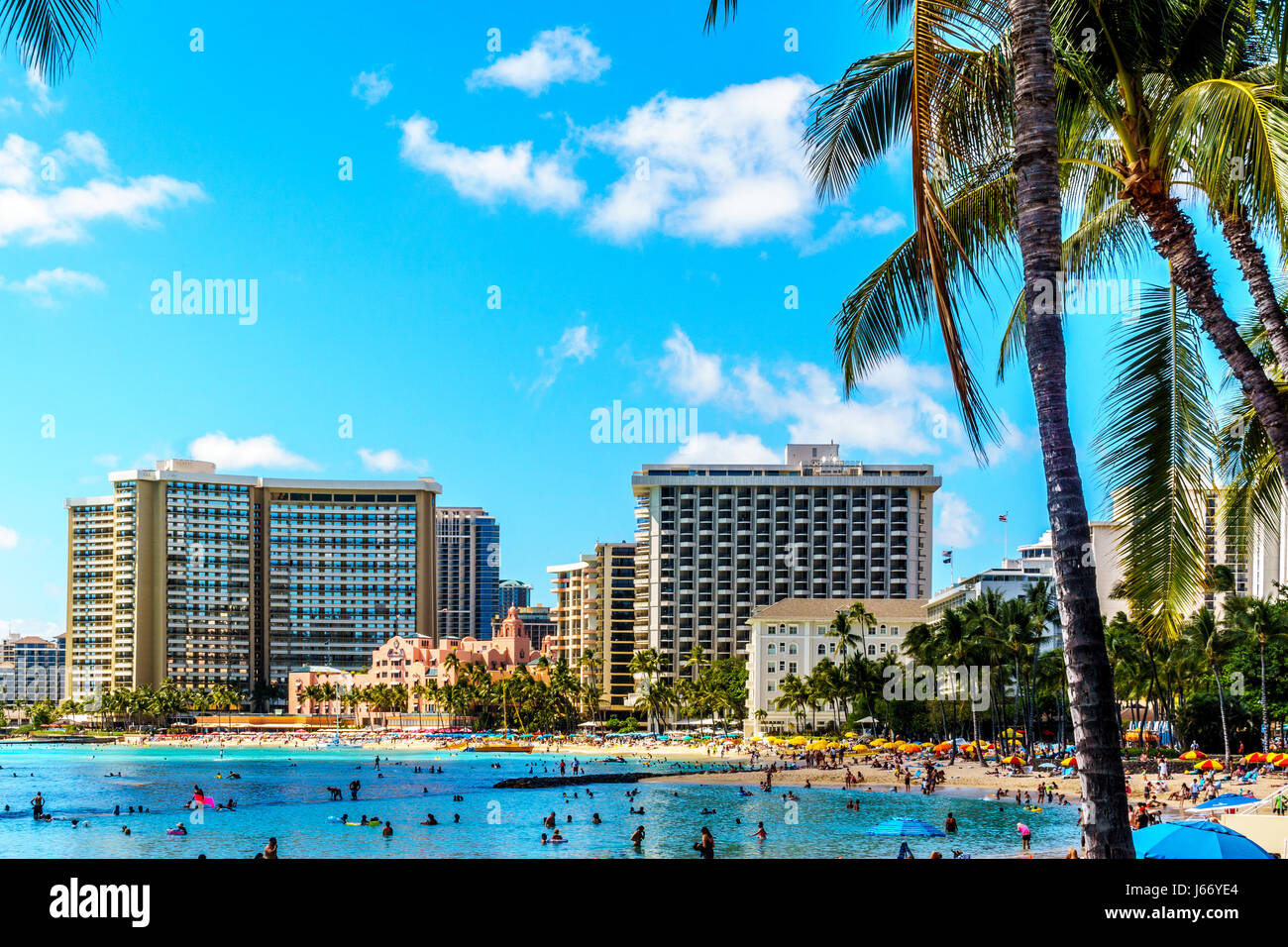 Waikiki Beach, with its many resorts under blue sky and white sand ...