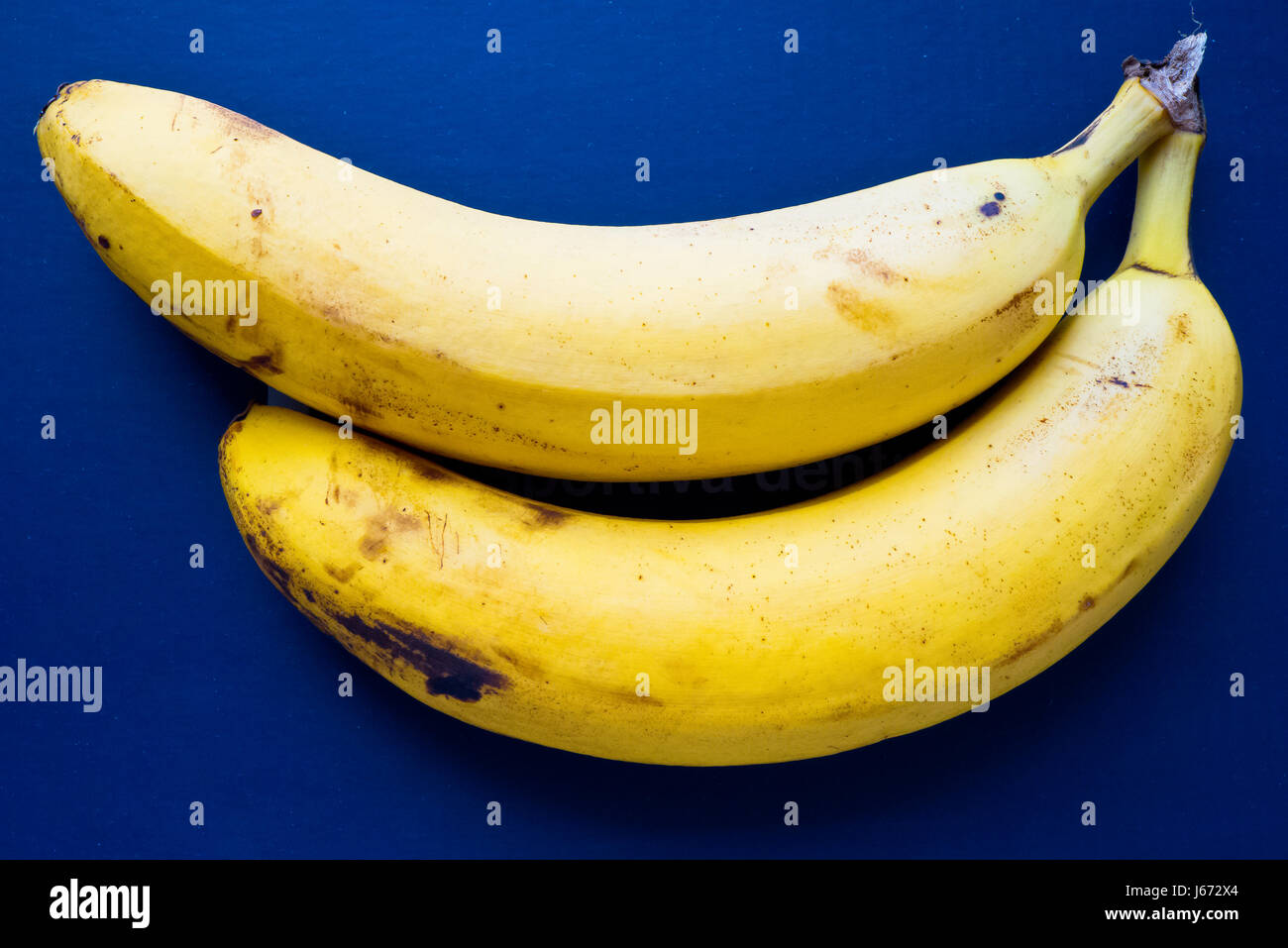 Bananas on blue background Stock Photo - Alamy