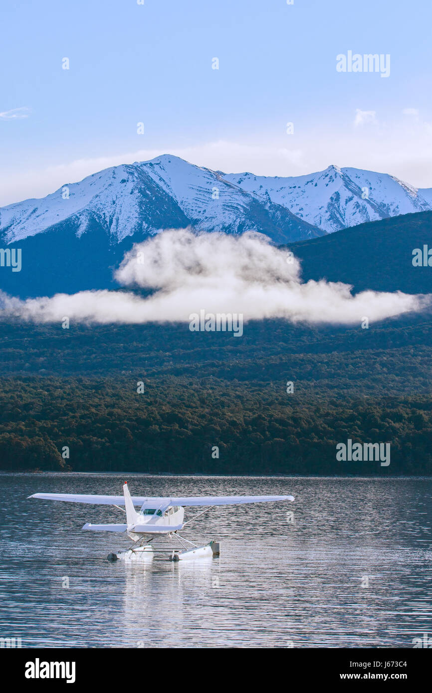 water plane floating over fresh water lake against beautiful mountain ...