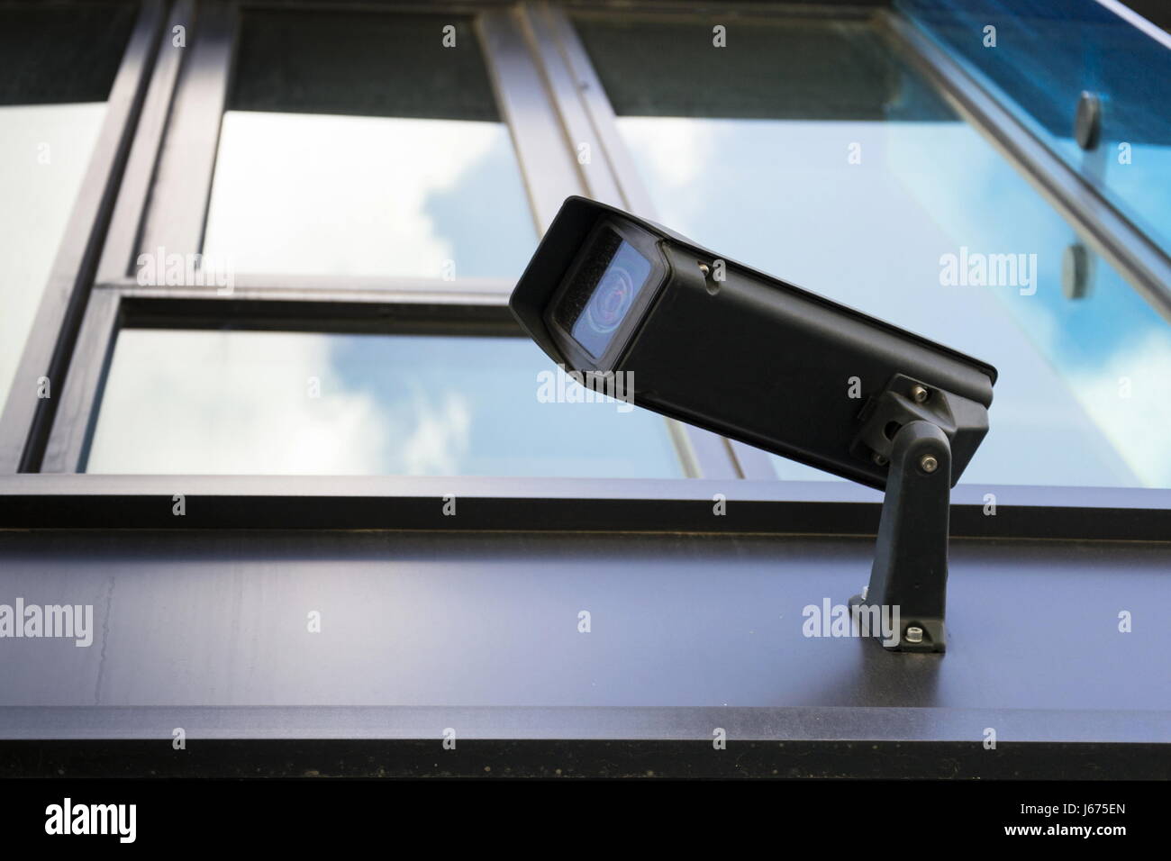 Grey security camera with window reflecting blue sky clouds Stock Photo ...