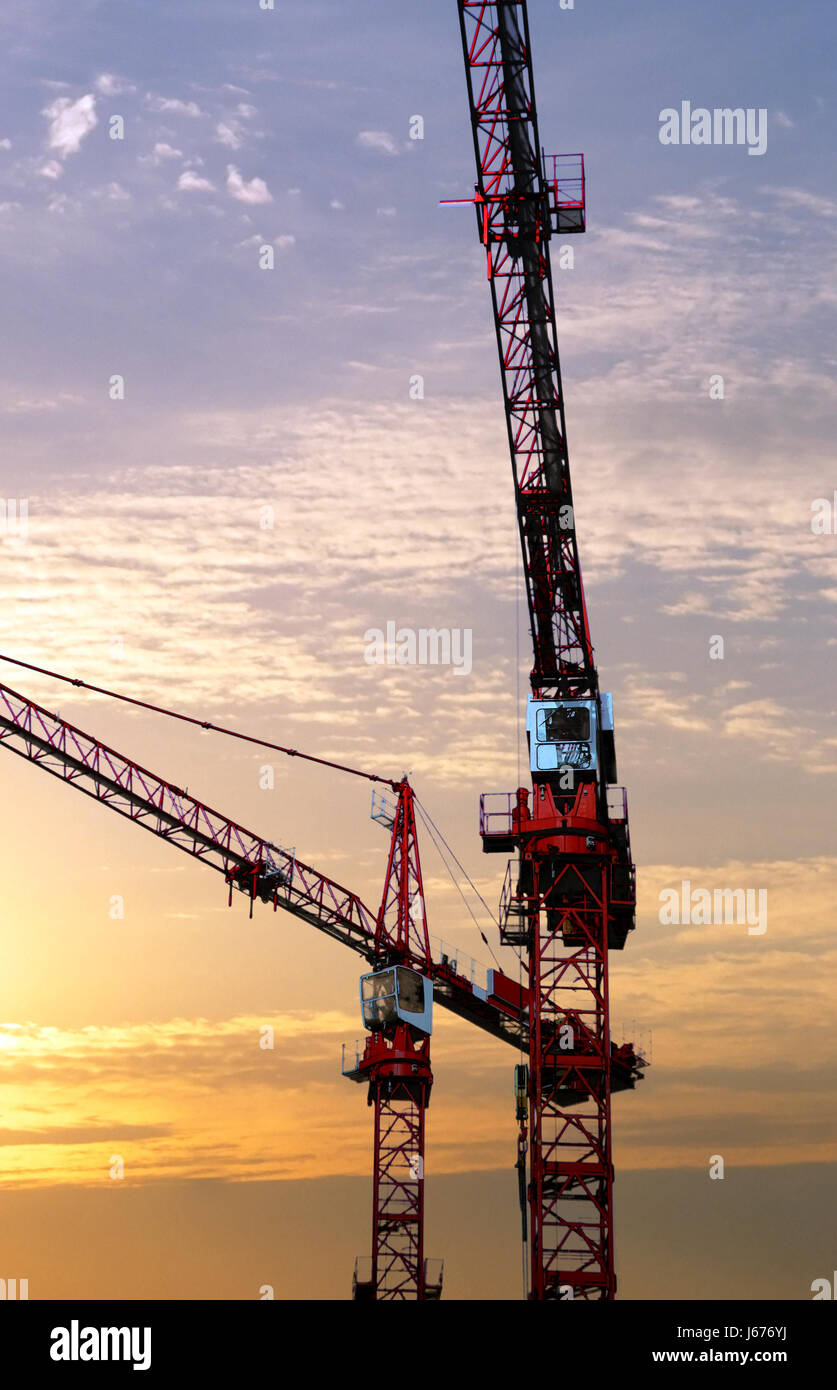 contrast high tall red building two crane cranes works tower elevator ...